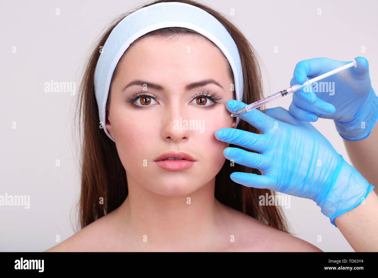 Young woman receiving plastic surgery injection on her face close up ...