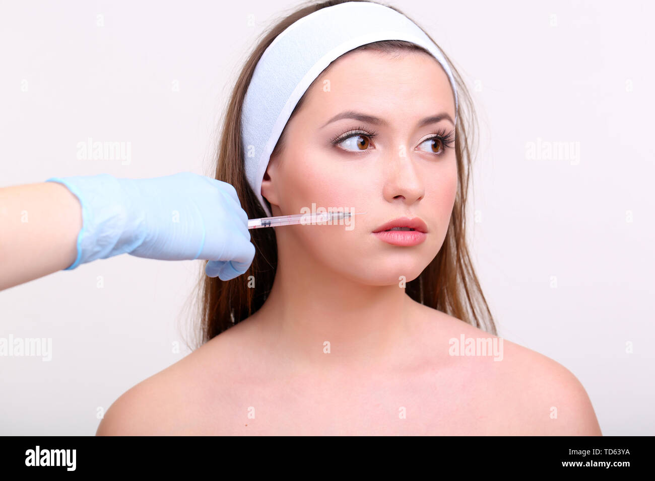 Young woman receiving plastic surgery injection on her face close up ...