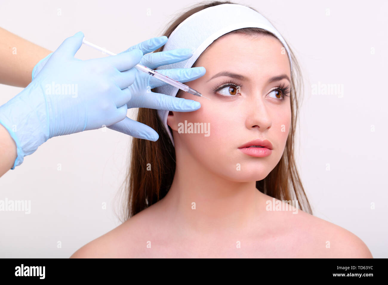 Young woman receiving plastic surgery injection on her face close up ...