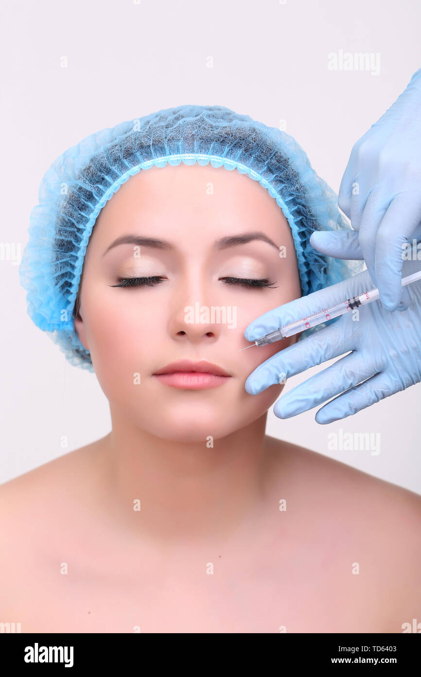 Young woman receiving plastic surgery injection on her face close up ...