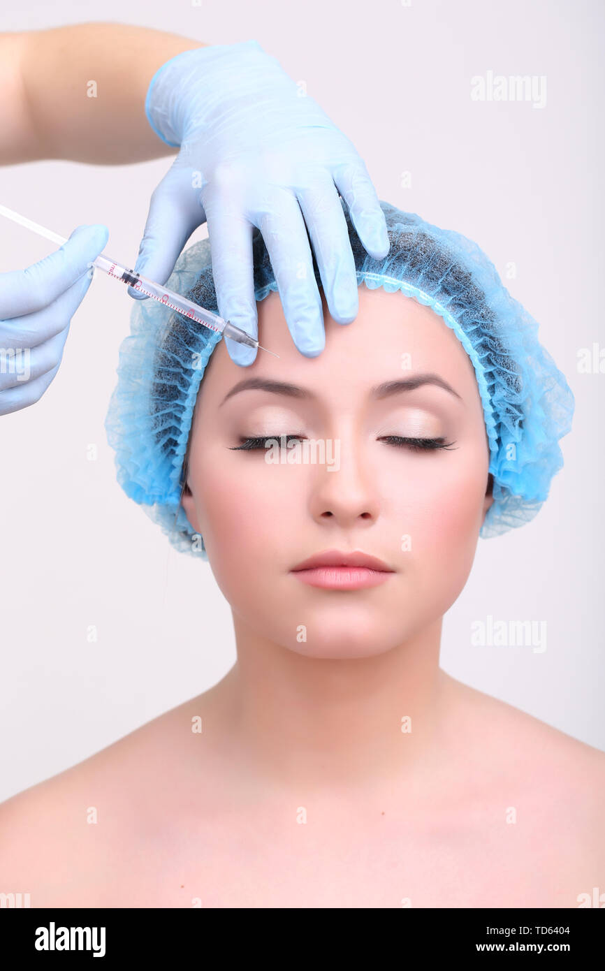 Young woman receiving plastic surgery injection on her face close up ...