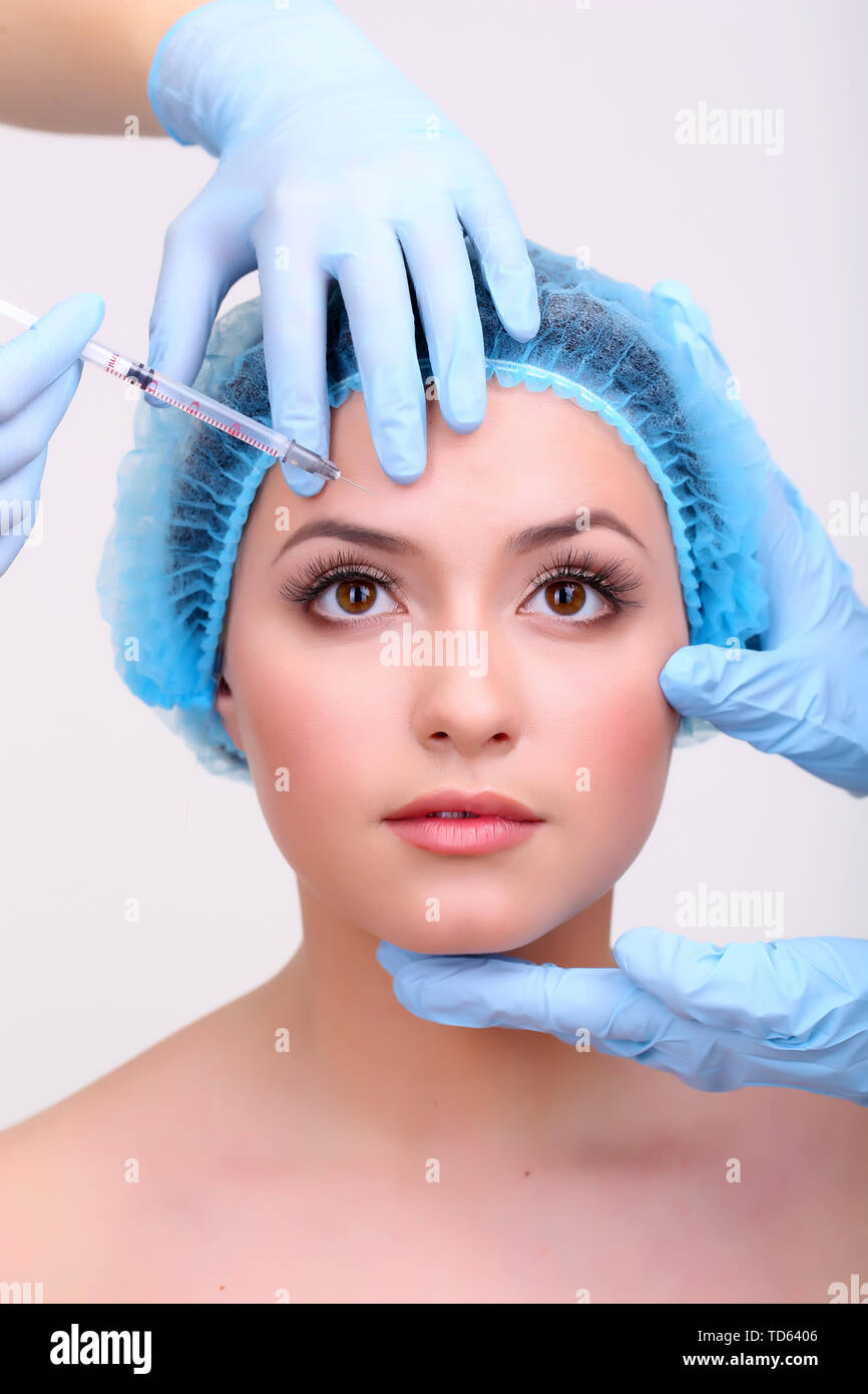 Young woman receiving plastic surgery injection on her face close up ...