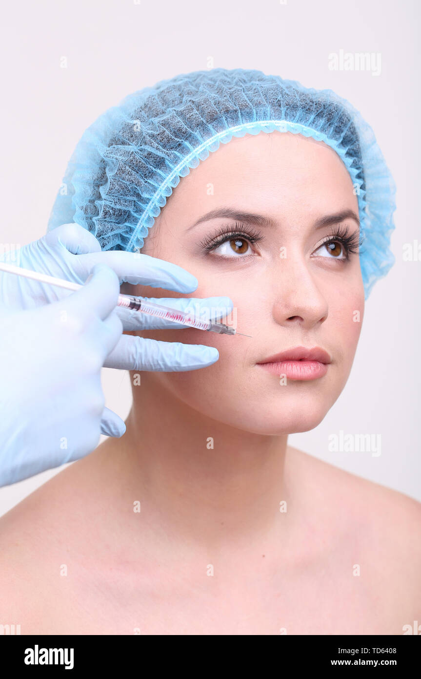 Young woman receiving plastic surgery injection on her face close up ...