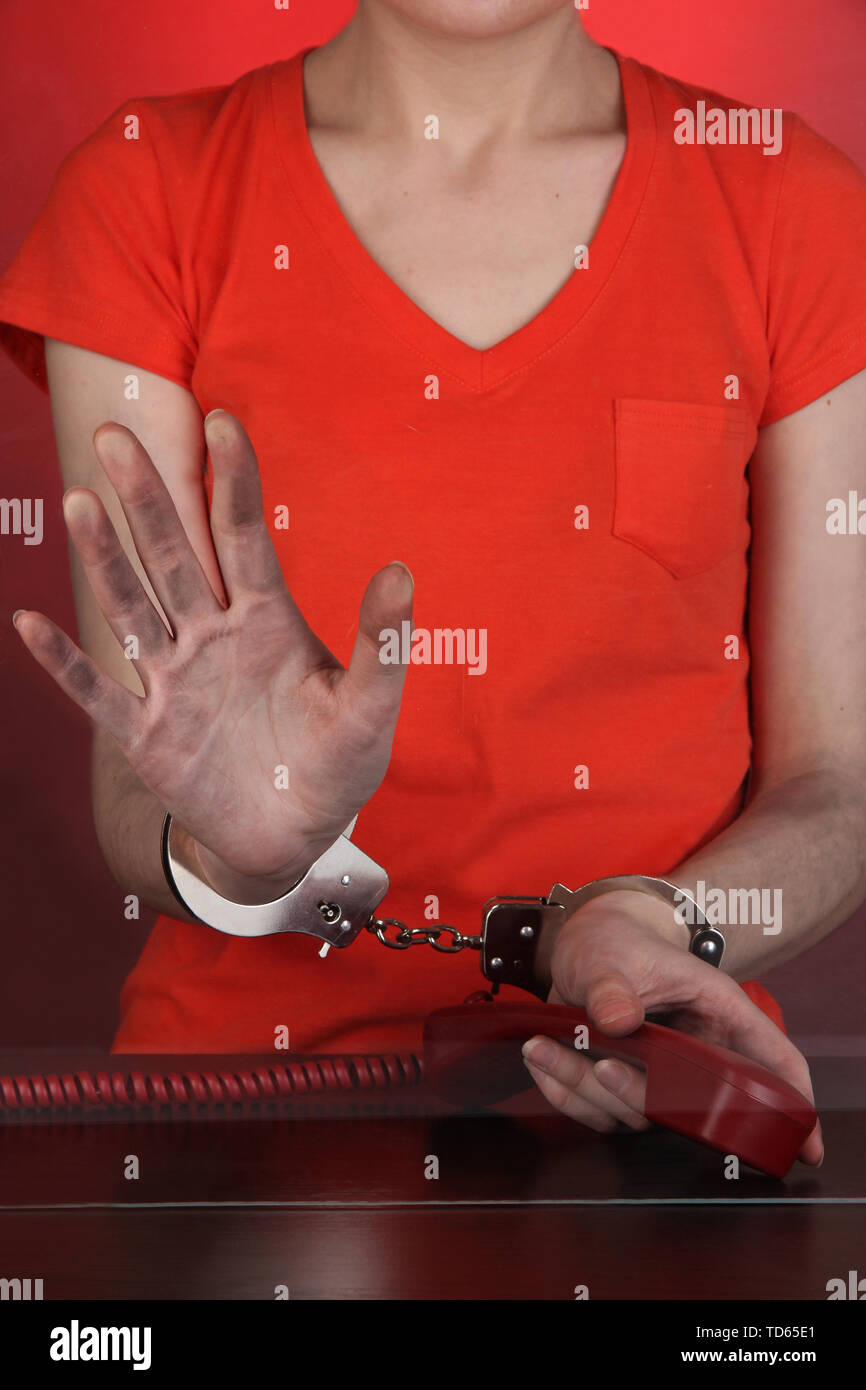 Prisoner in handcuffs behind glass in soundproof room Stock Photo - Alamy