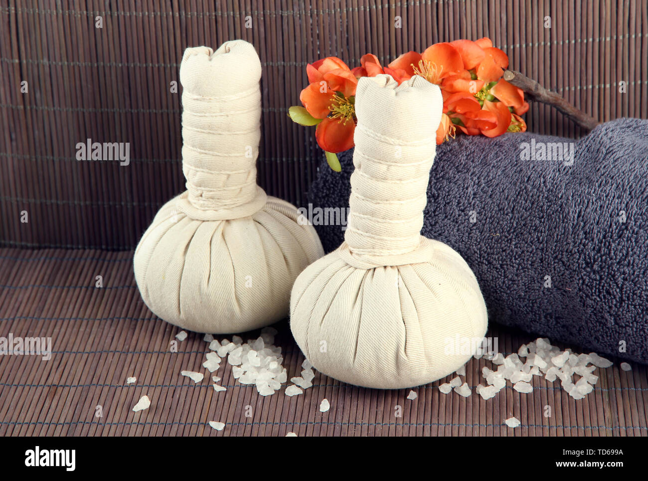 Herbal compress balls for spa treatment and towel on bamboo background ...