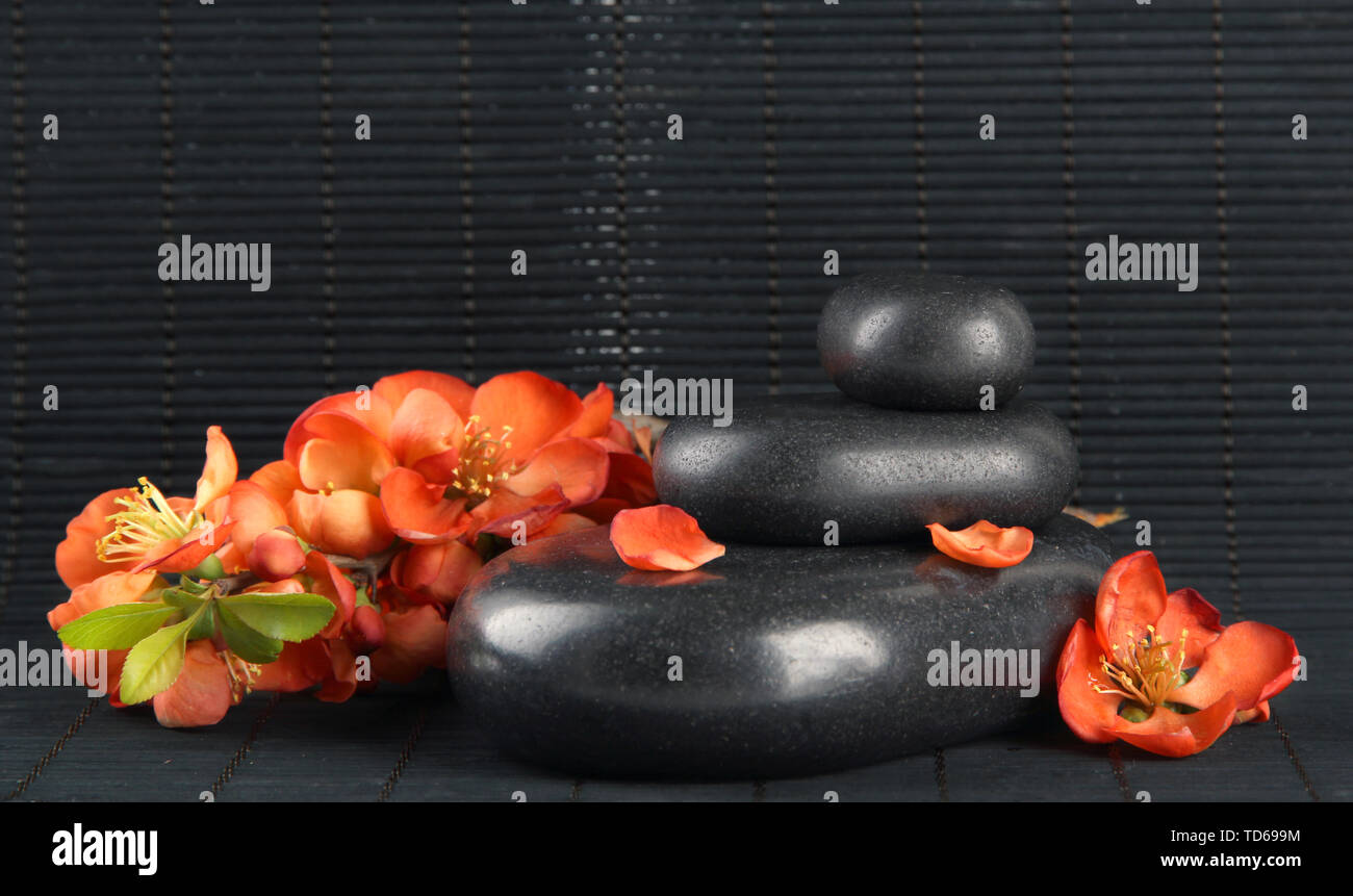 Spa stones and flowers on bamboo background Stock Photo - Alamy
