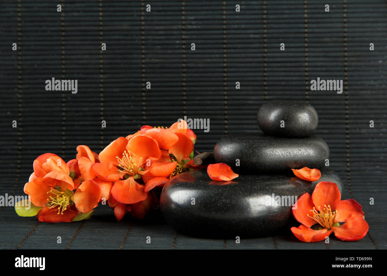 Spa stones and flowers on bamboo background Stock Photo - Alamy