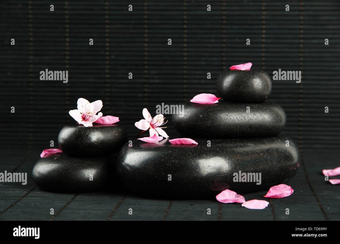 Spa stones and flowers on bamboo background Stock Photo - Alamy
