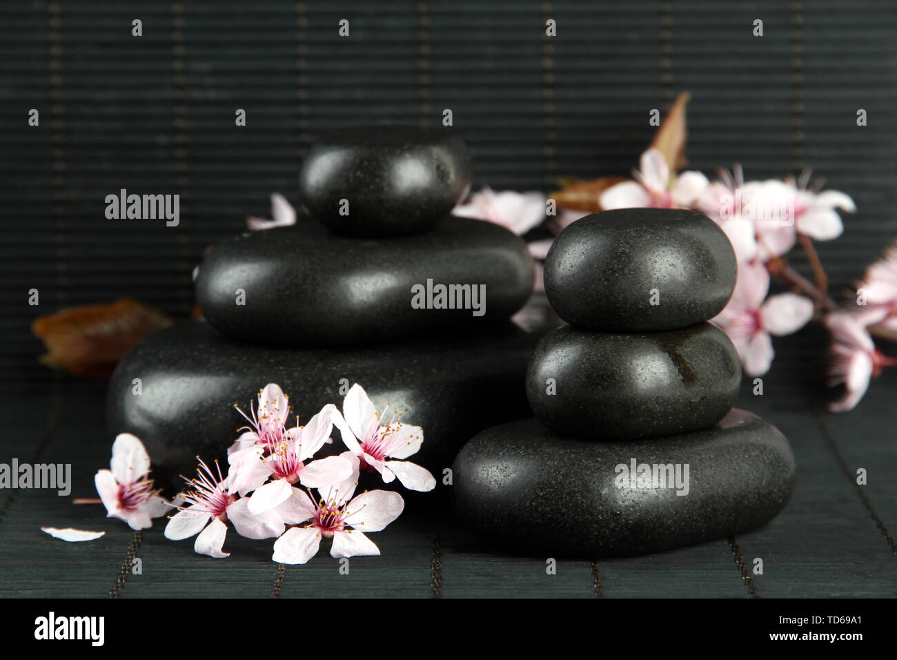 Spa stones and flowers on bamboo background Stock Photo - Alamy