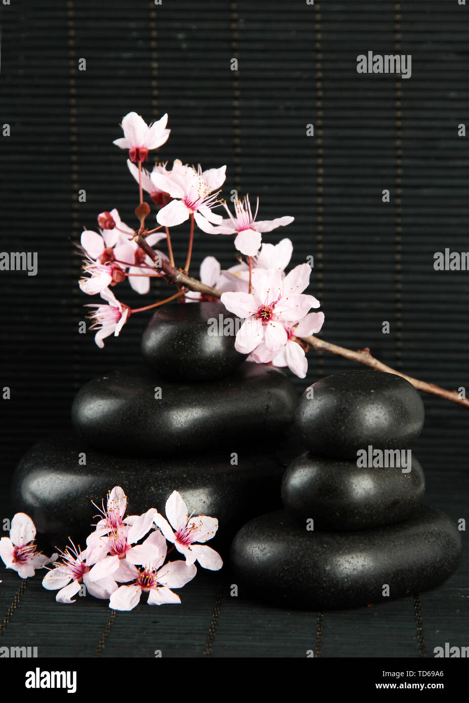 Spa stones and flowers on bamboo background Stock Photo - Alamy