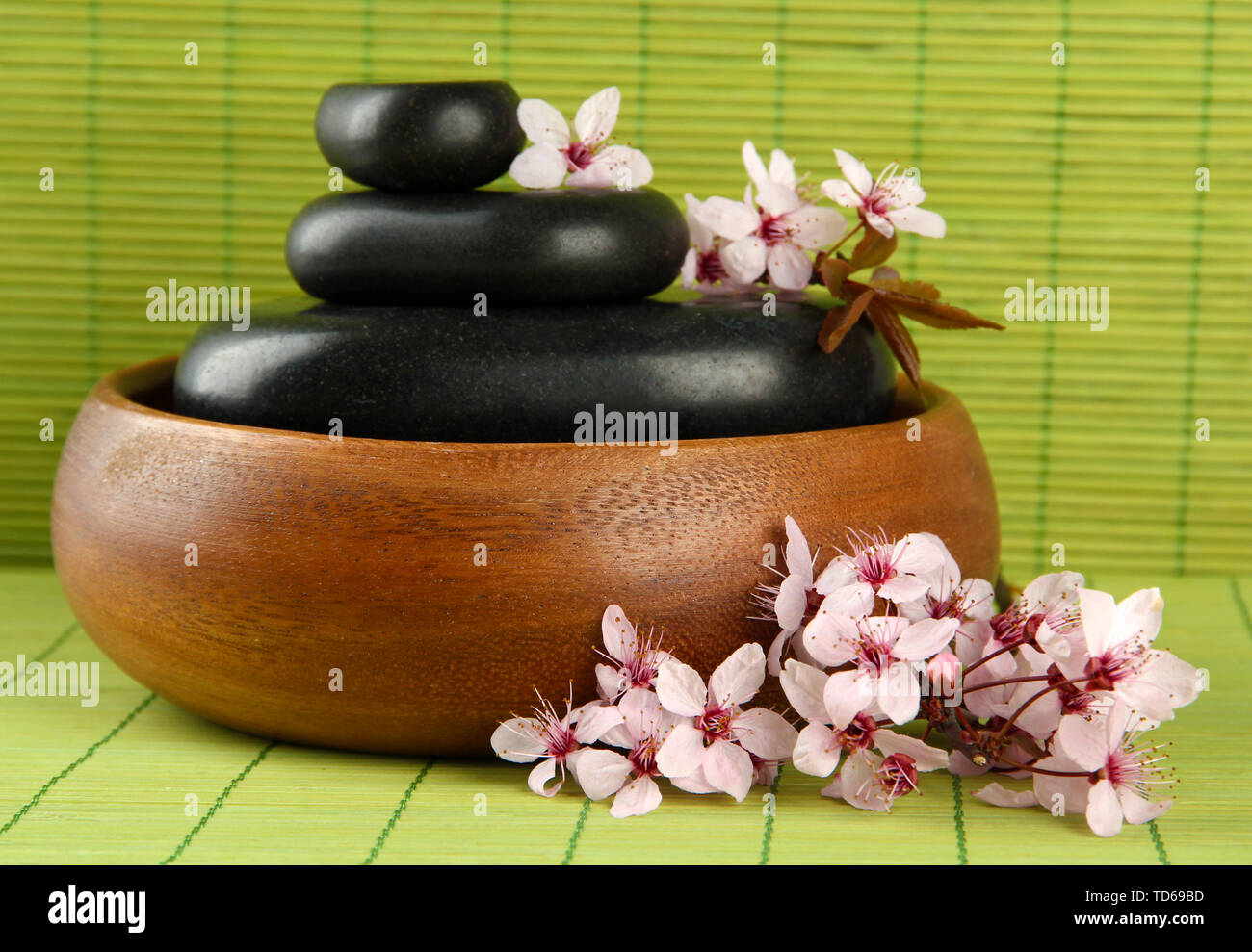 Spa stones and flowers on bamboo background Stock Photo - Alamy
