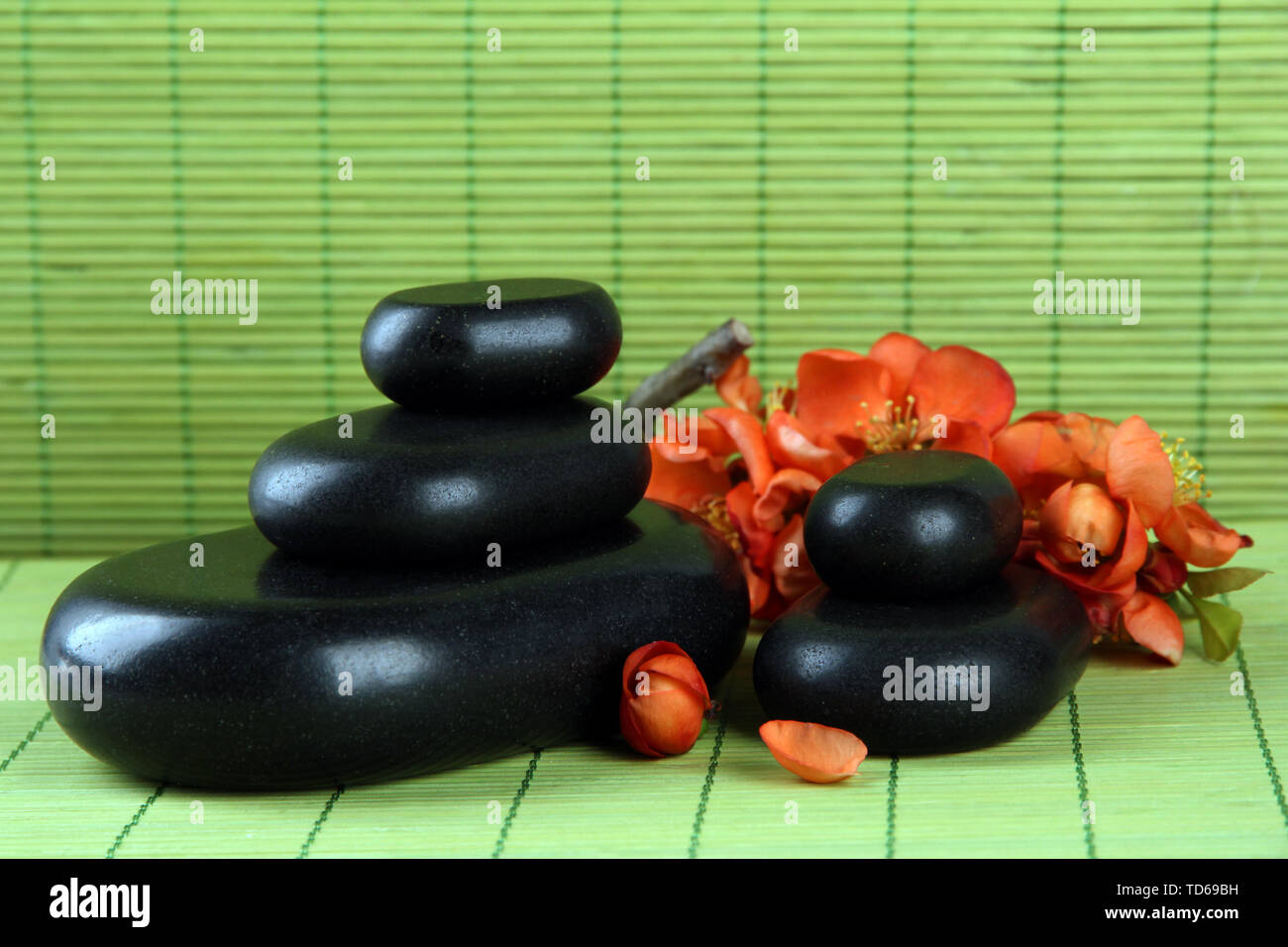 Spa stones and flowers on bamboo background Stock Photo - Alamy