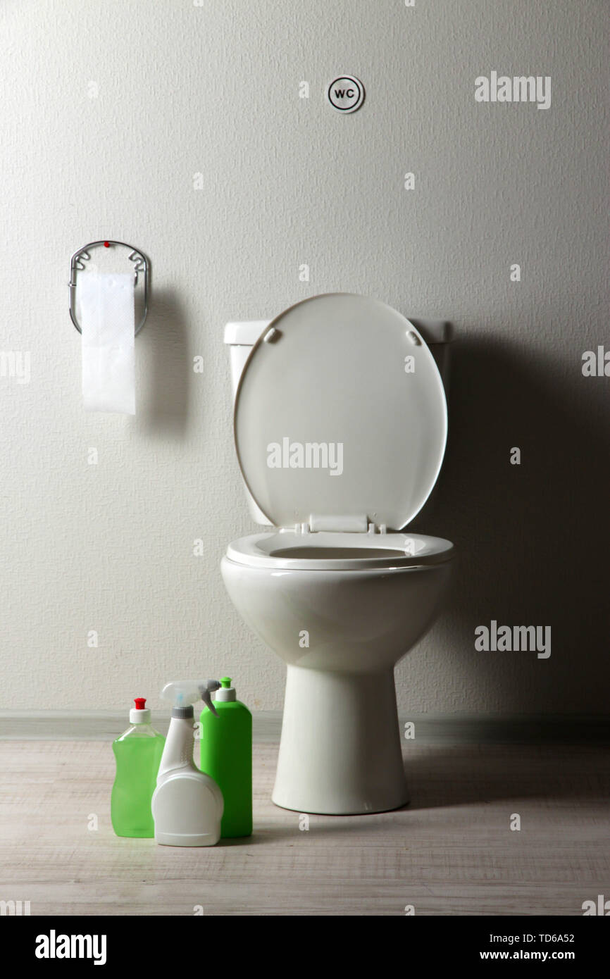 White toilet bowl and cleaning supplies in a bathroom Stock Photo - Alamy