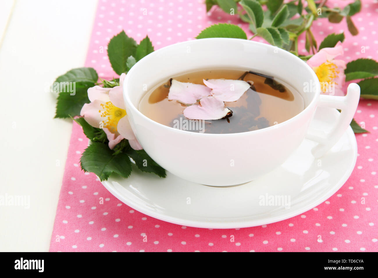 Cup of herbal tea with hip rose flowers on white wooden table Stock ...