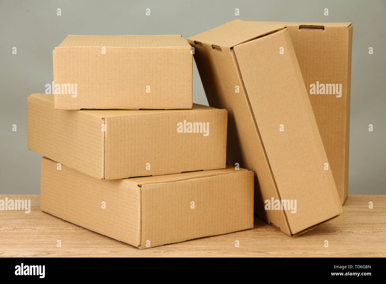 Parcels boxes on wooden table, on grey background Stock Photo - Alamy