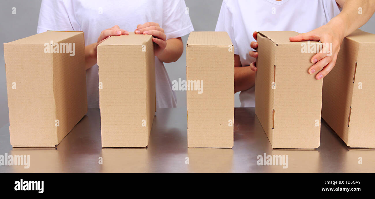 Workers working with boxes at conveyor belt, on grey background Stock ...