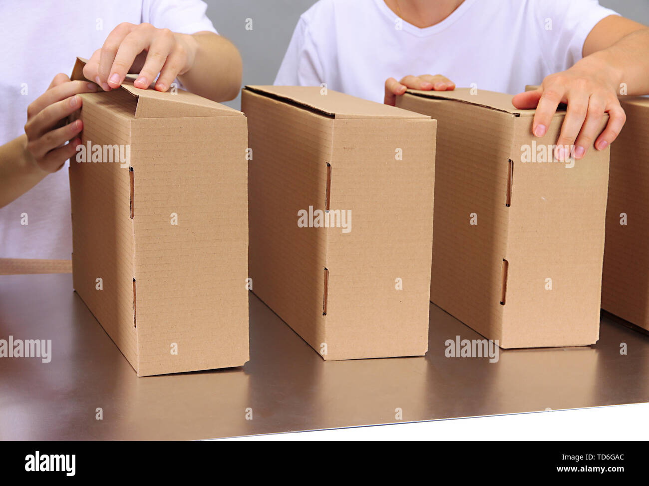 Workers working with boxes at conveyor belt, on grey background Stock ...