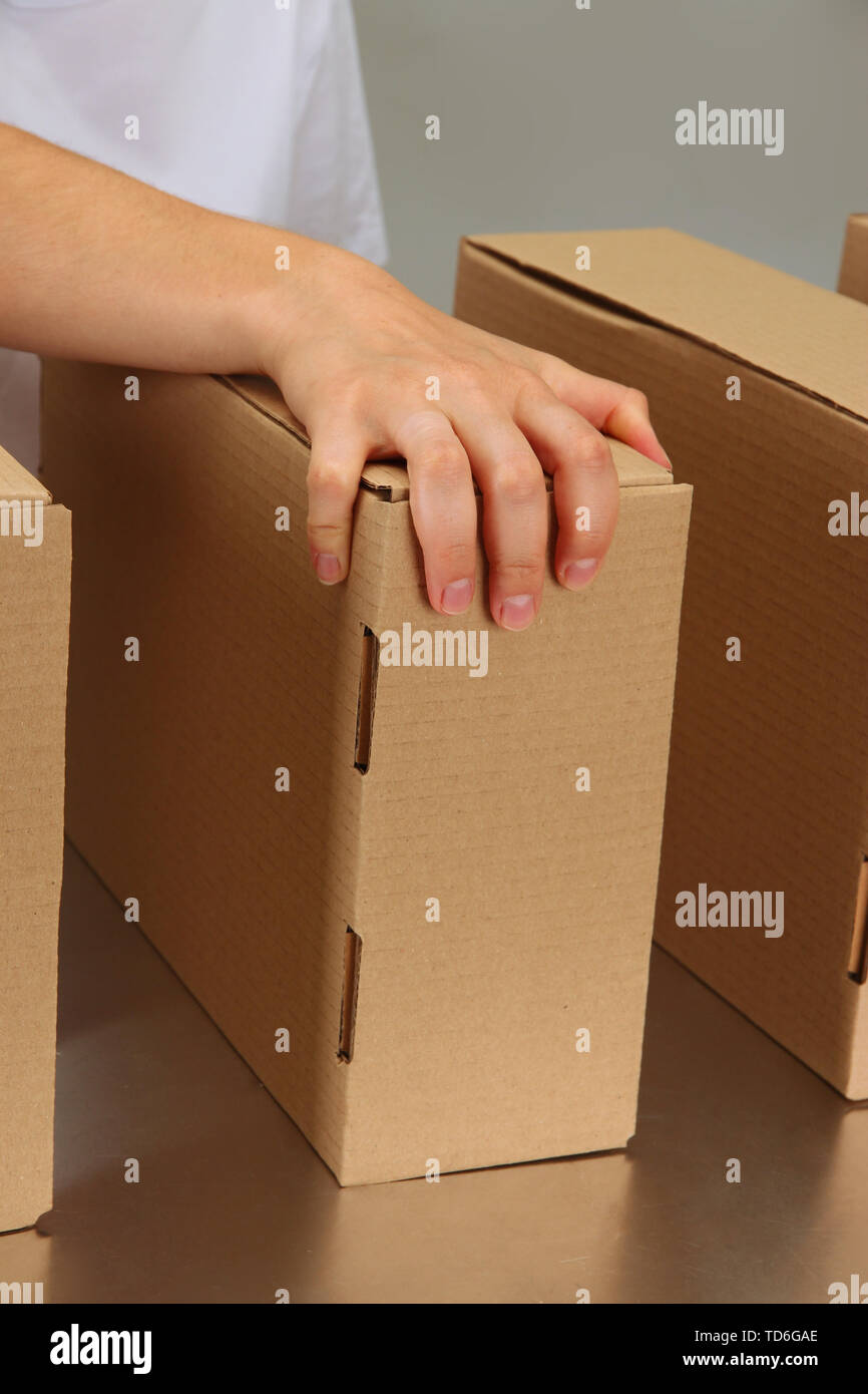 Worker working with boxes at conveyor belt, on grey background Stock ...