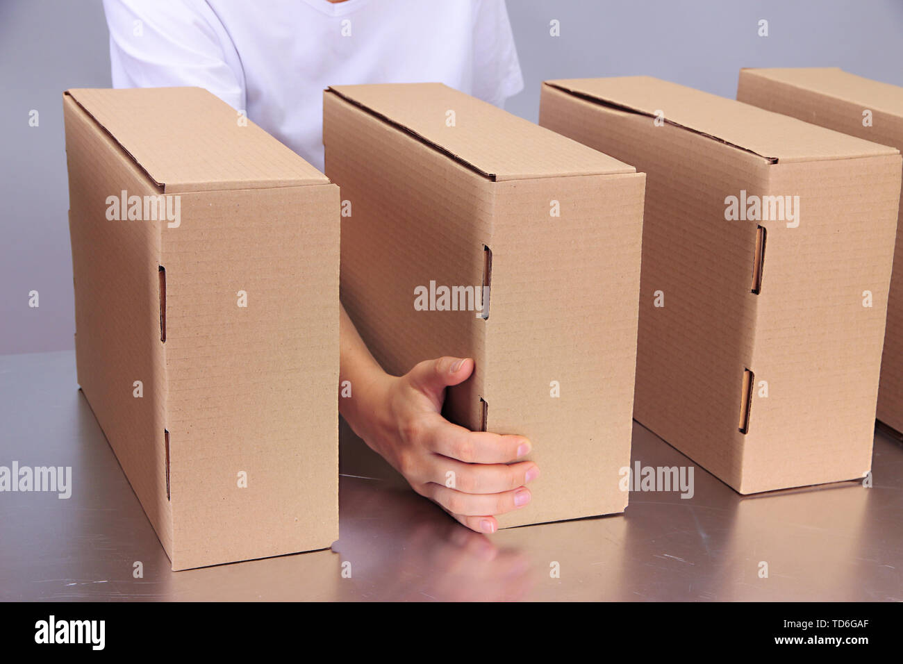 Worker working with boxes at conveyor belt, on grey background Stock ...