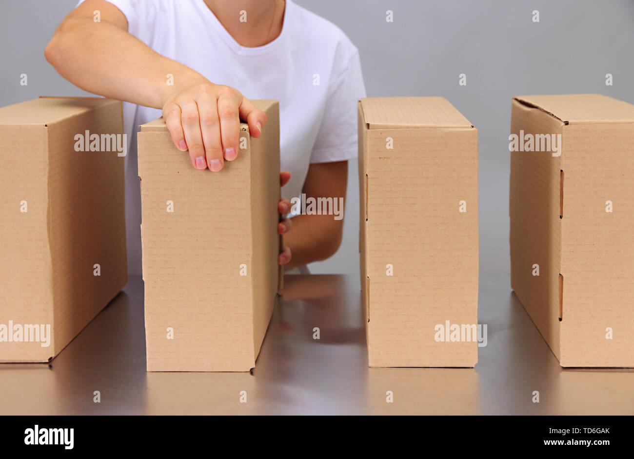 Worker working with boxes at conveyor belt, on grey background Stock ...