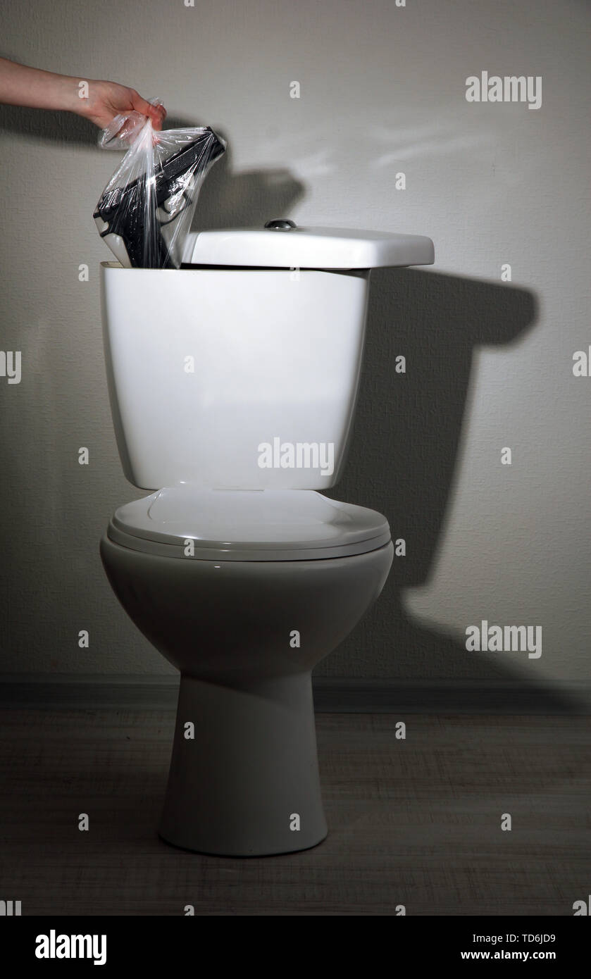 Hand hides gun in toilet tank in a bathroom Stock Photo - Alamy