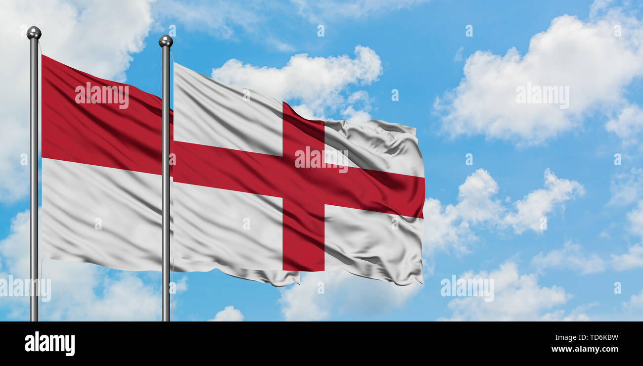 Iraq and England flag waving in the wind against white cloudy blue sky ...