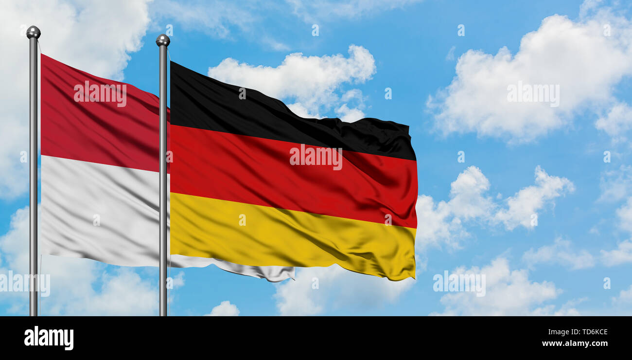 Iraq and Germany flag waving in the wind against white cloudy blue sky ...