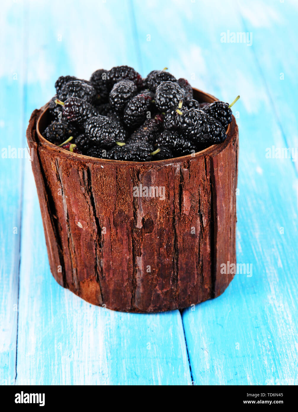 Ripe mulberries in bowl on wooden background Stock Photo - Alamy