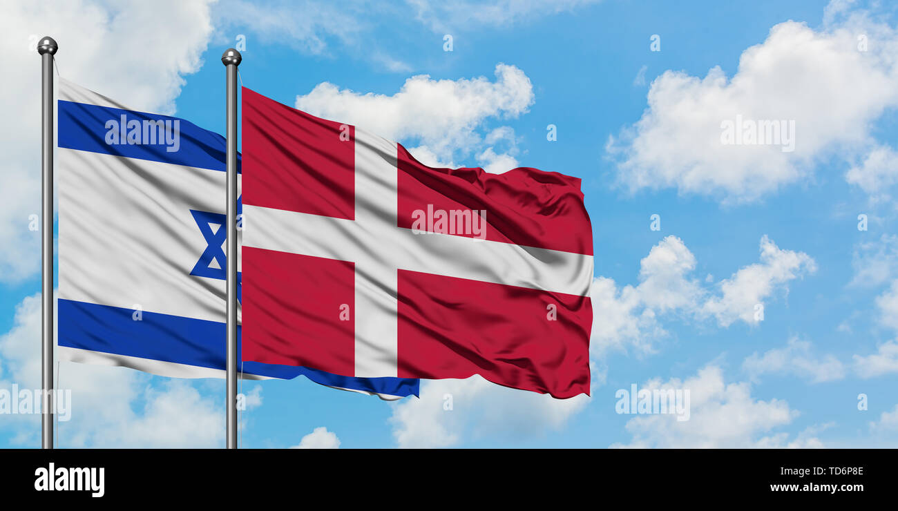 Israel and Denmark flag waving in the wind against white cloudy blue ...
