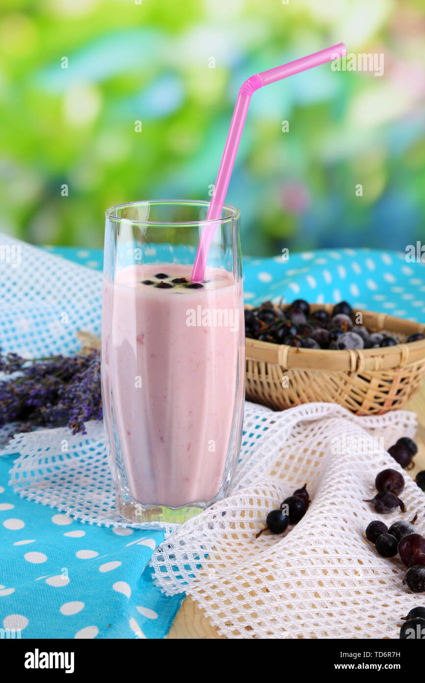 Delicious milk shake with blackberry on wooden table on natural ...