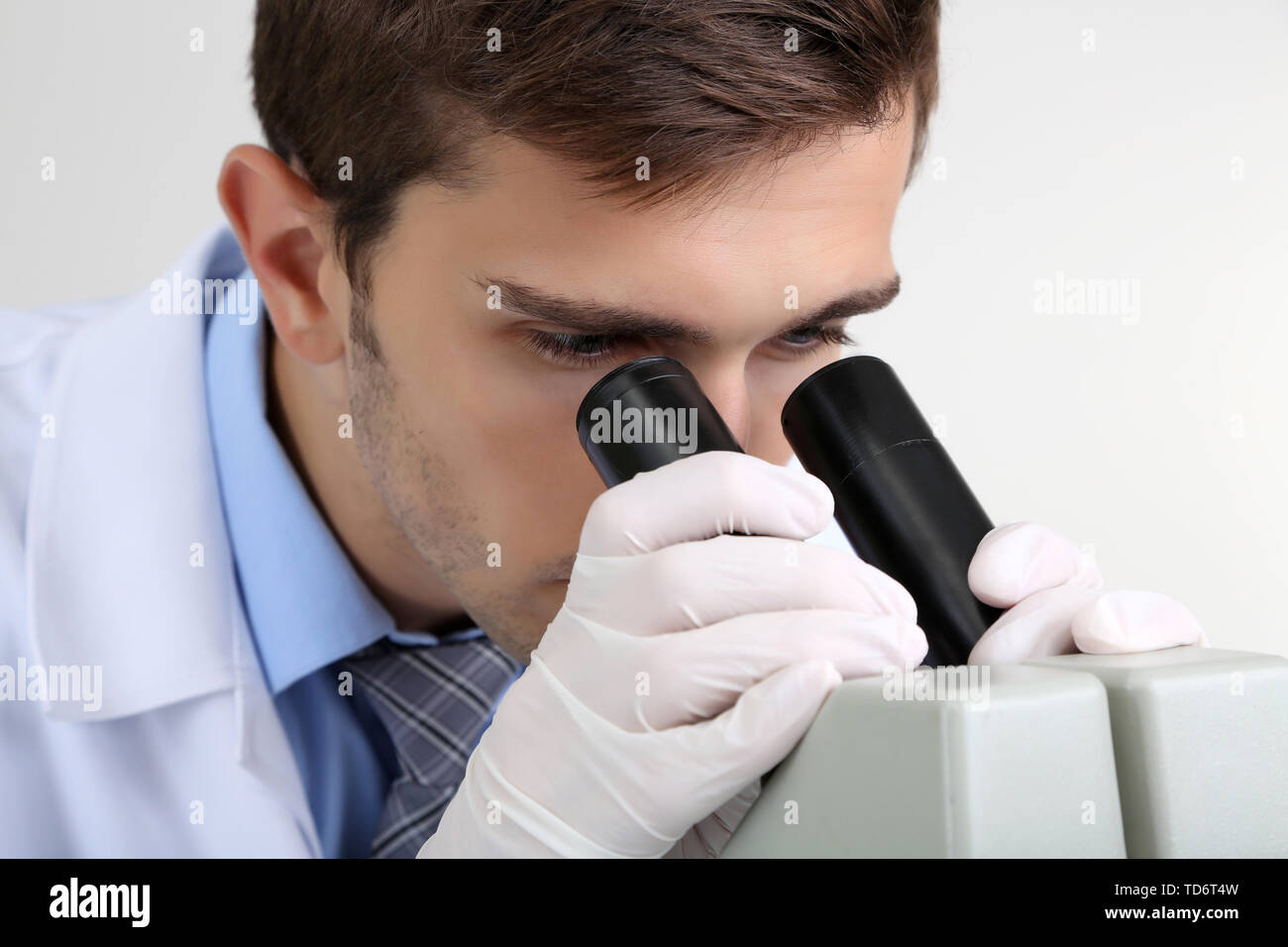 Scientist in uniform looking microscope hi-res stock photography and ...