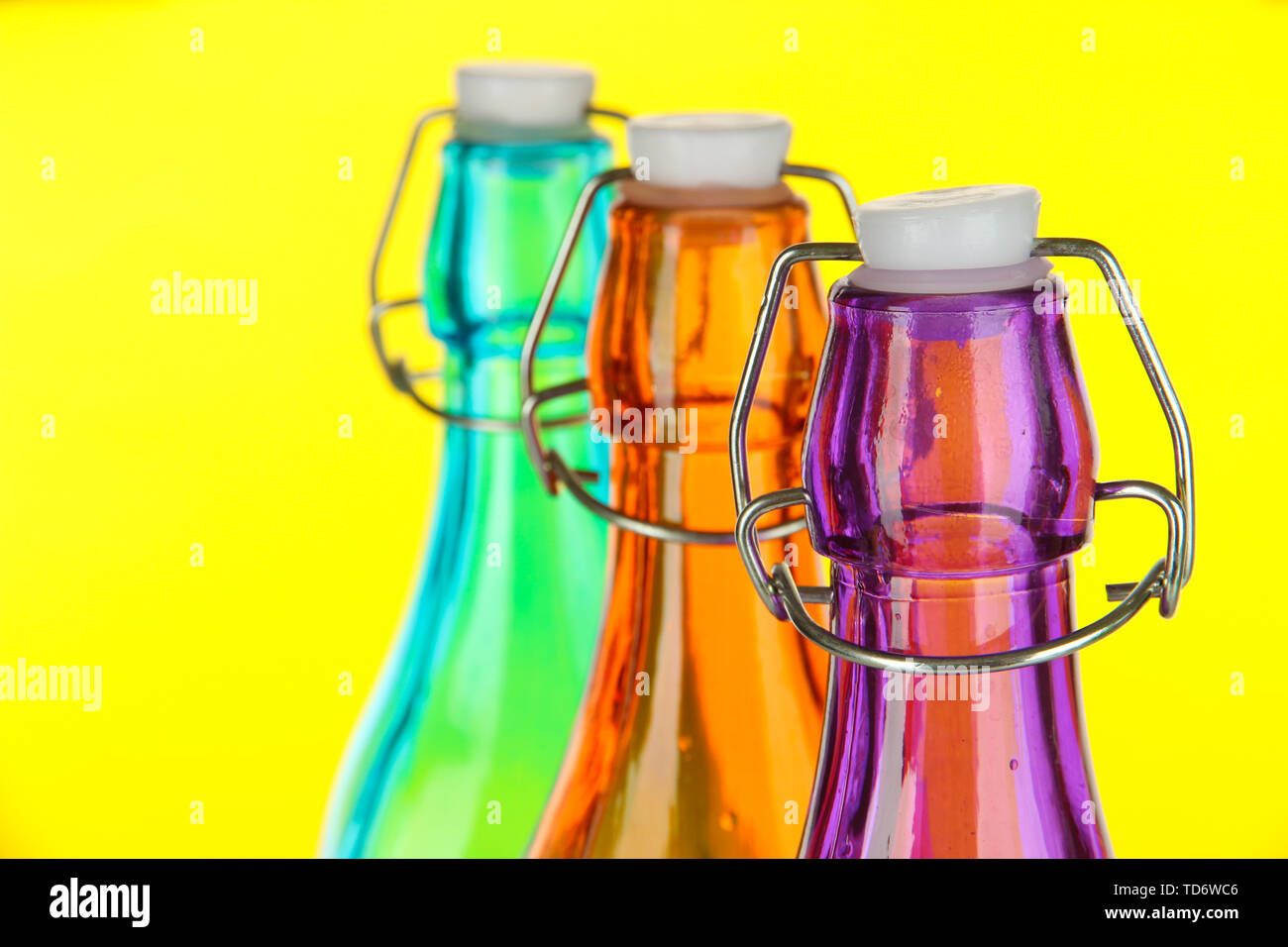 Colorful bottles on yellow background Stock Photo - Alamy