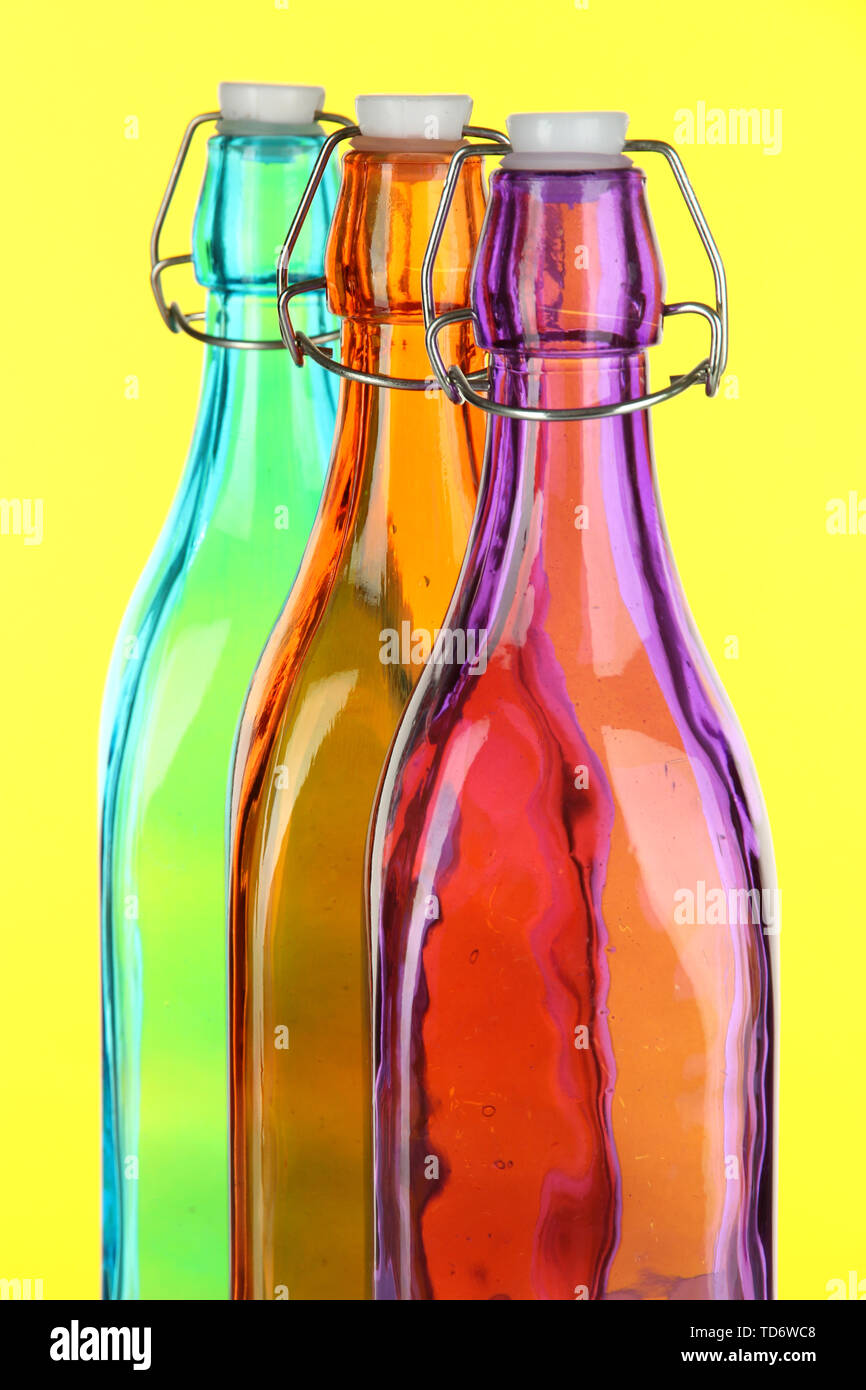 Colorful bottles on yellow background Stock Photo - Alamy