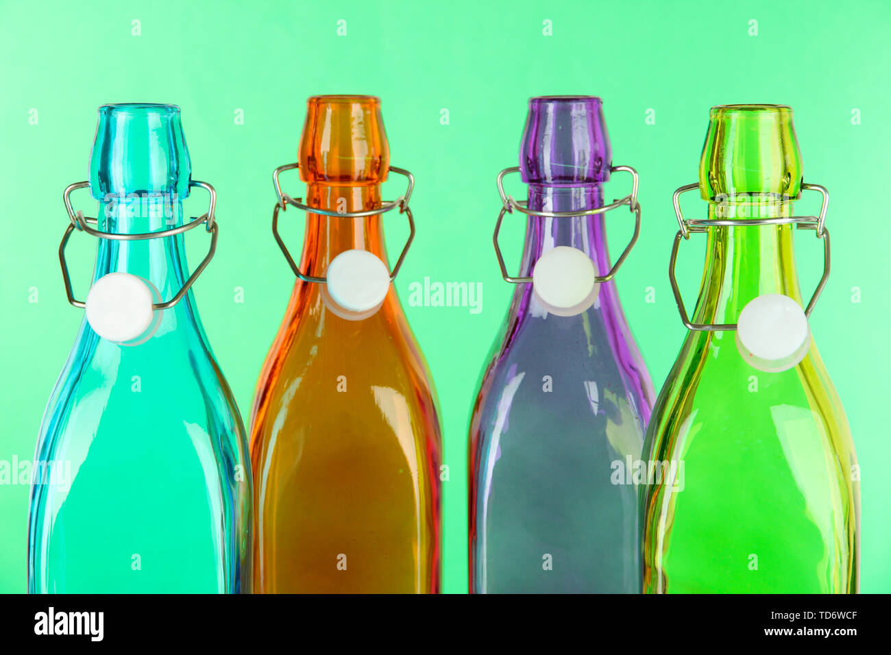 Colorful bottles on green background Stock Photo - Alamy