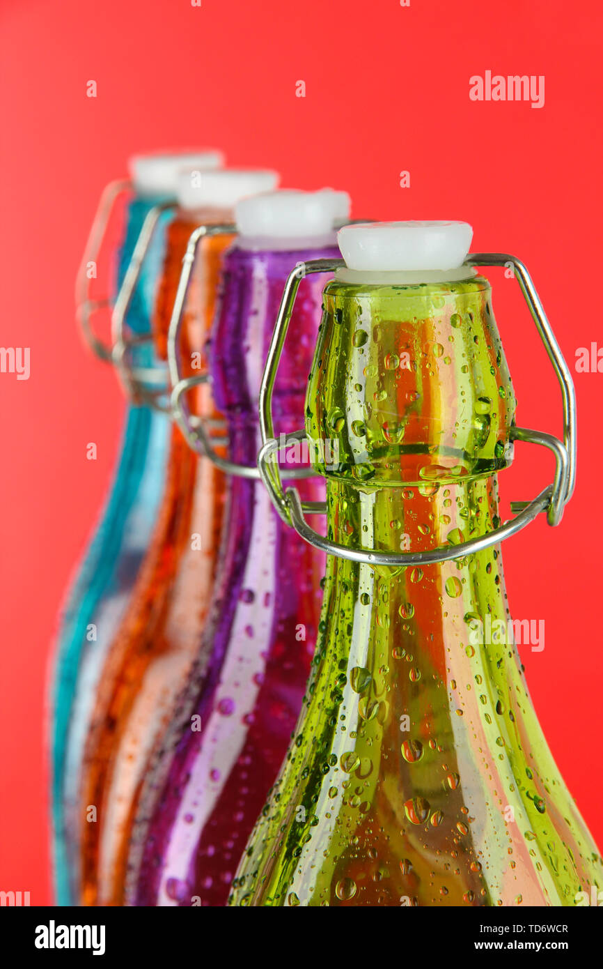 Colorful bottles on red background Stock Photo - Alamy