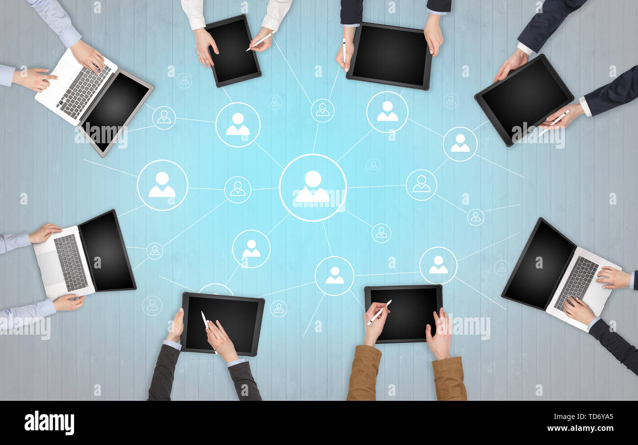 Group of people with devices in hands working in team on tablets ...