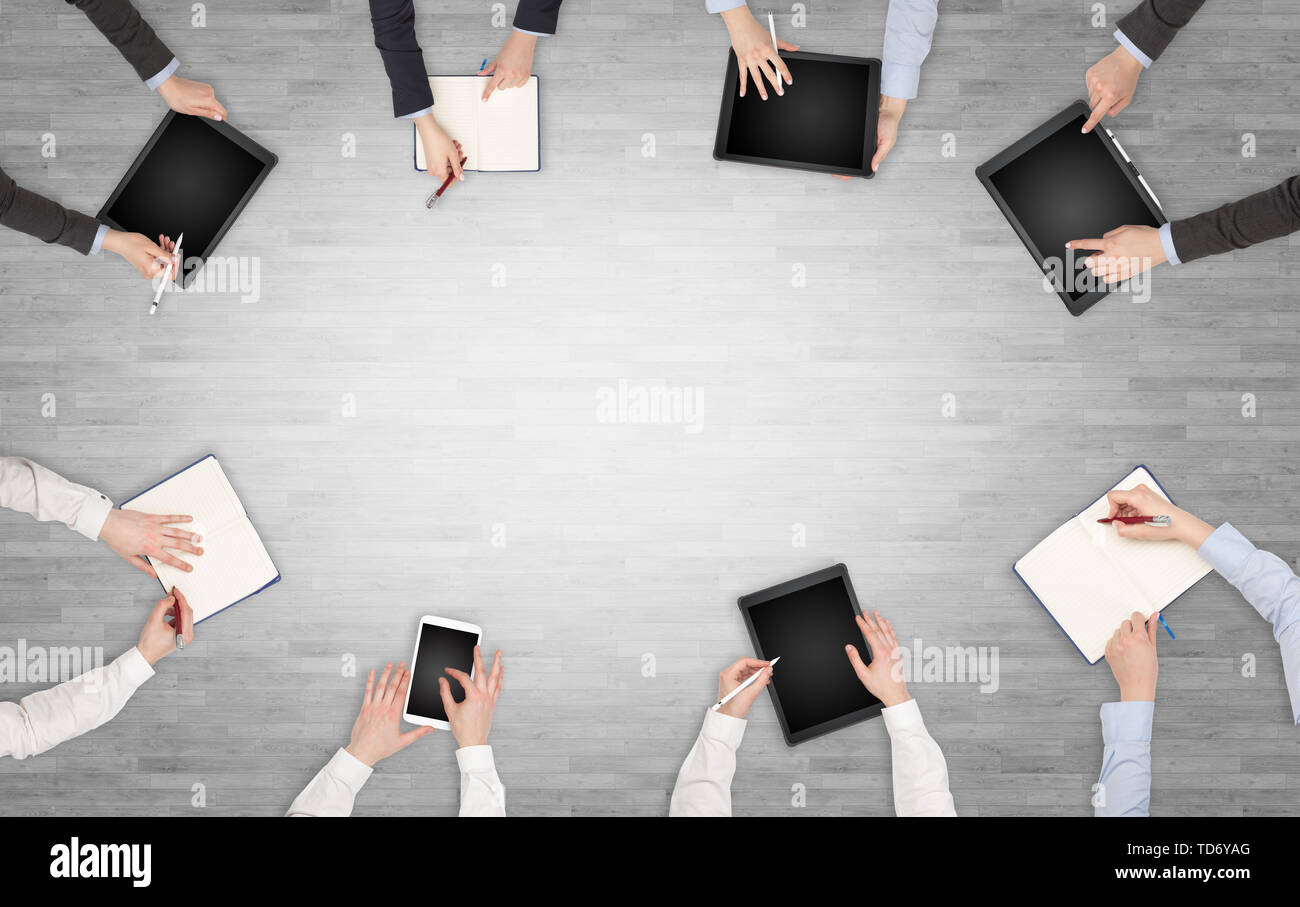 Group of people with devices in hands having desk discussion and making ...