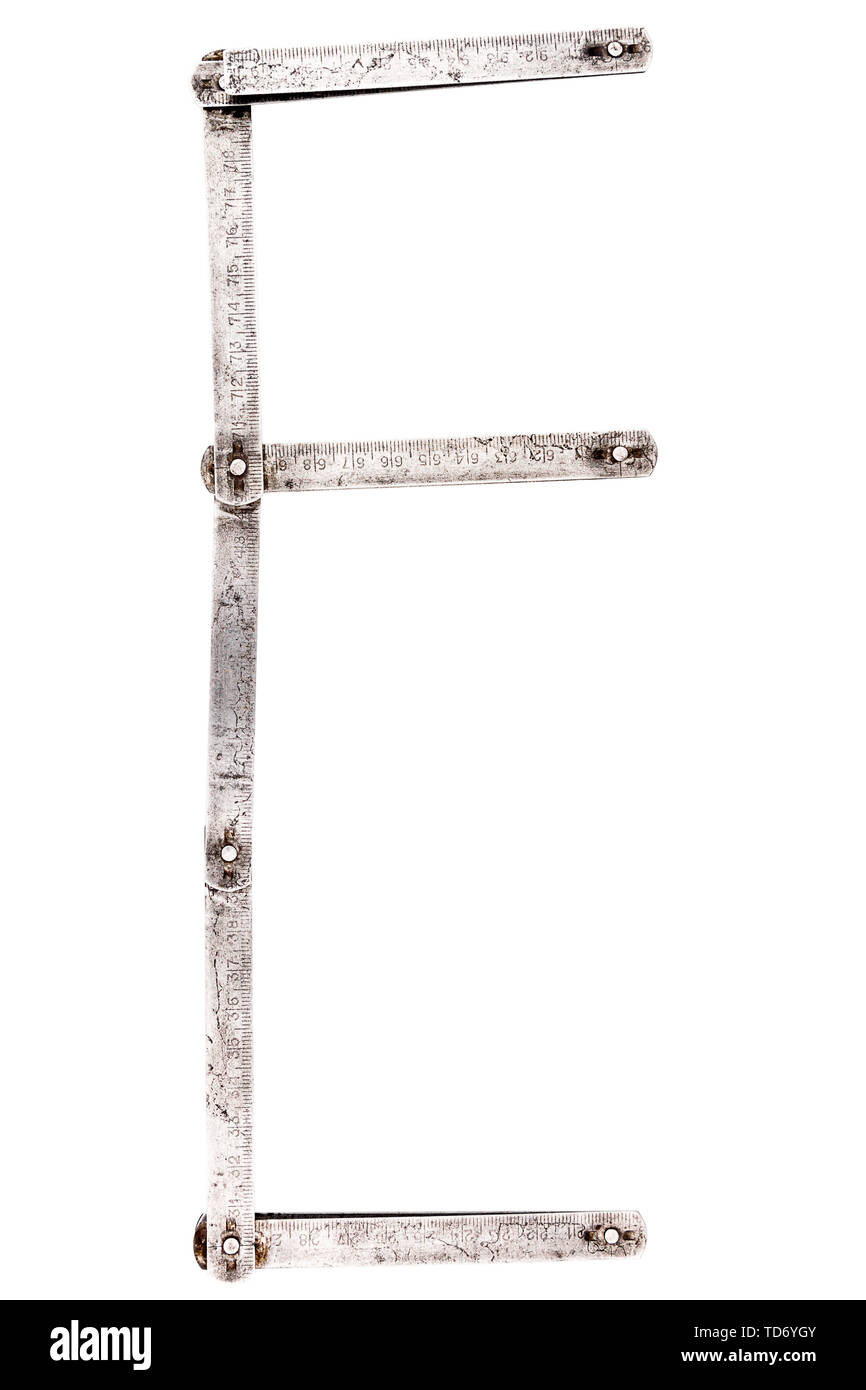 Old iron meter ruler. Old iron folding meter in the shape of letter E ...