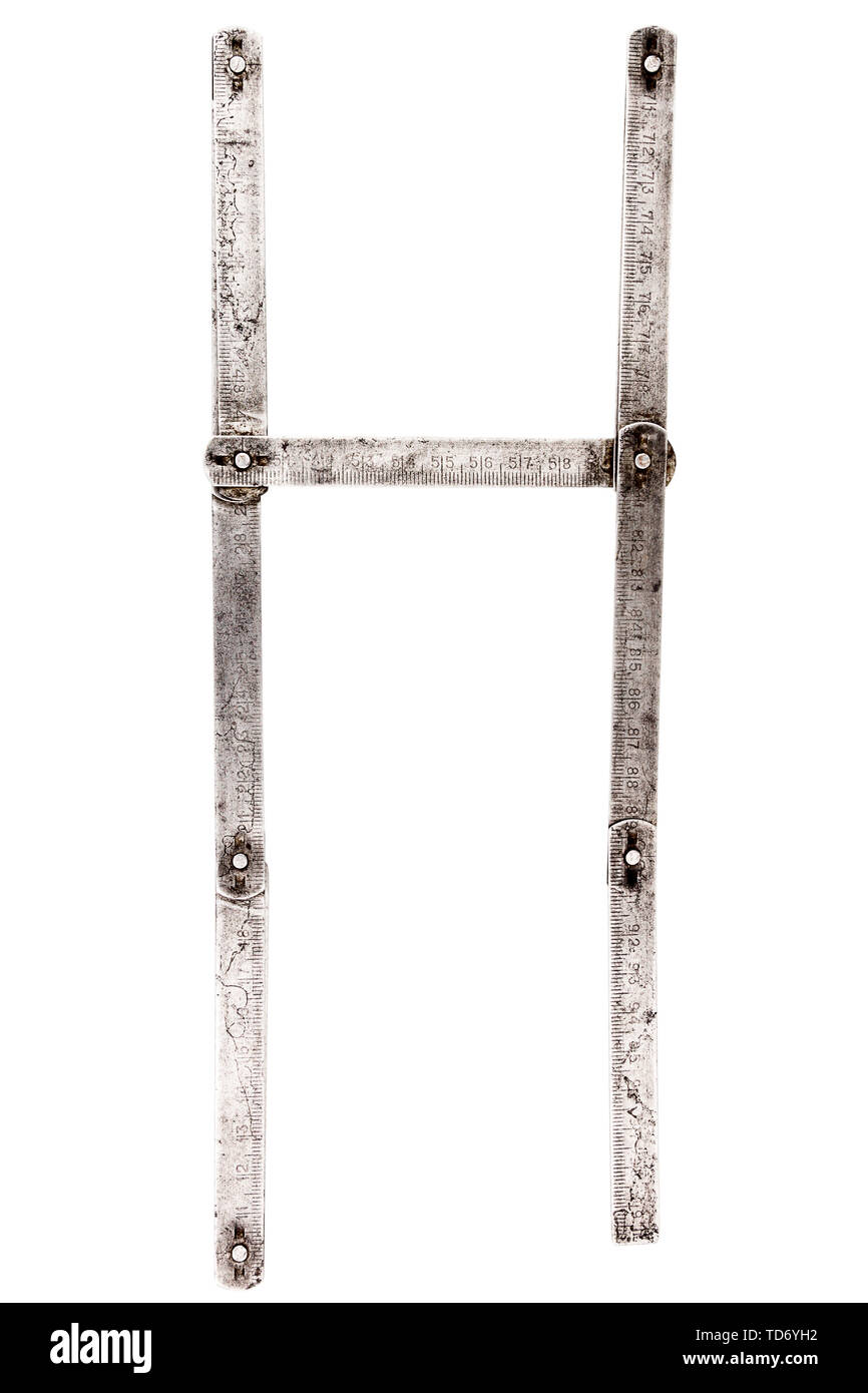 Old iron meter ruler. Old iron folding meter in the shape of letter H ...