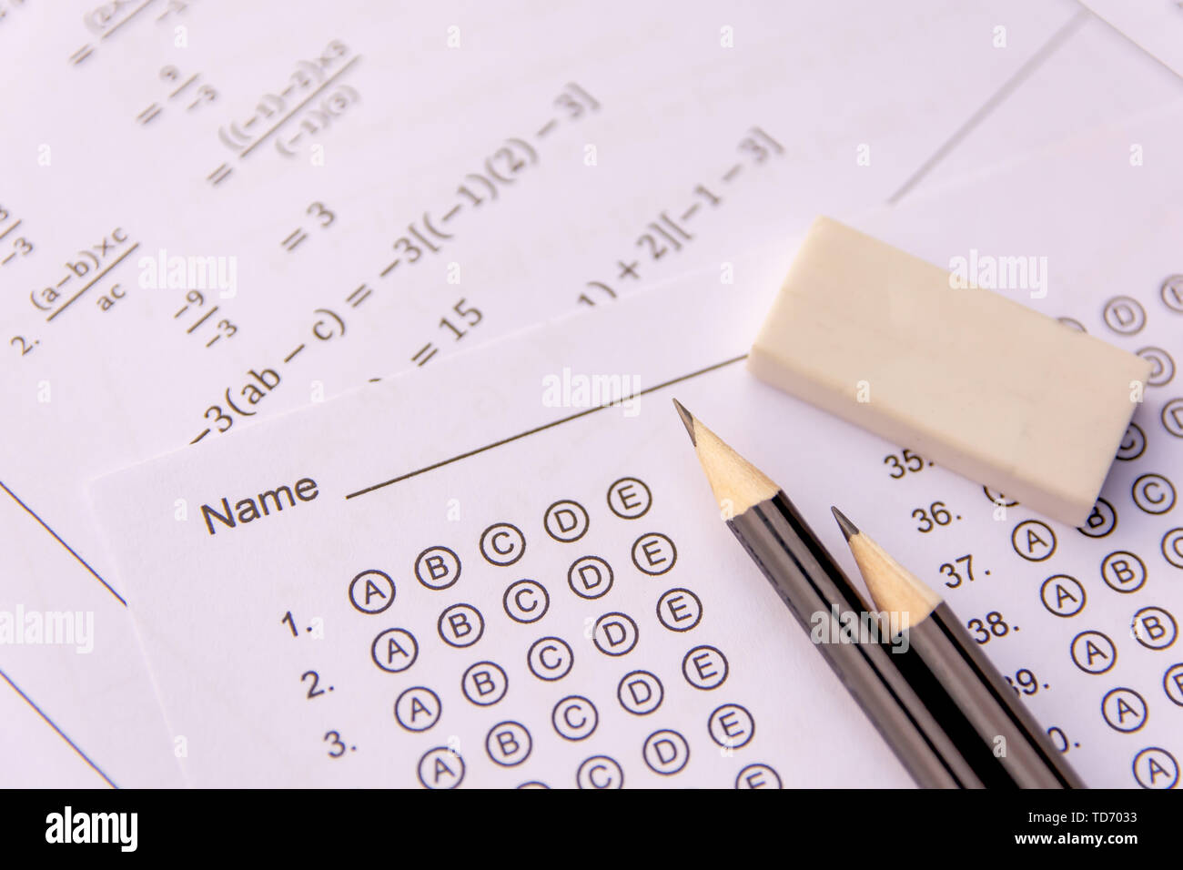 Pencil and eraser on answer sheets or Standardized test form with ...