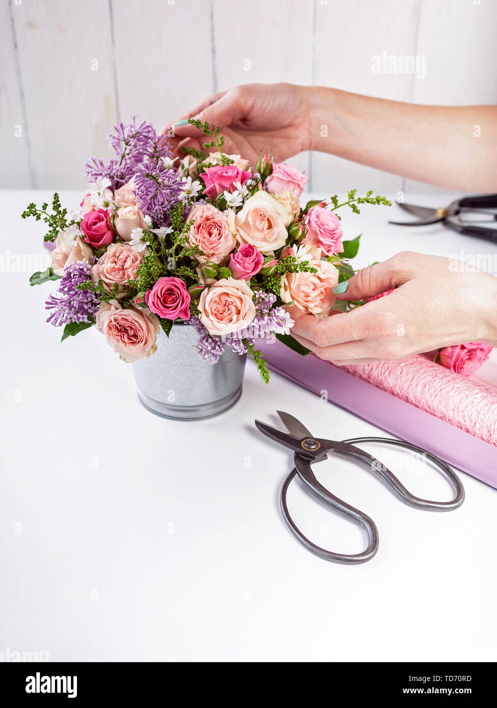 Florist at work. Elegant florist hands make bouquet on white background ...