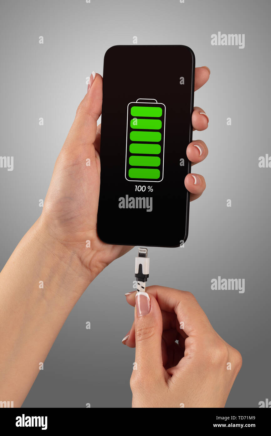 Elegant hand charging cellphone with low battery Stock Photo - Alamy