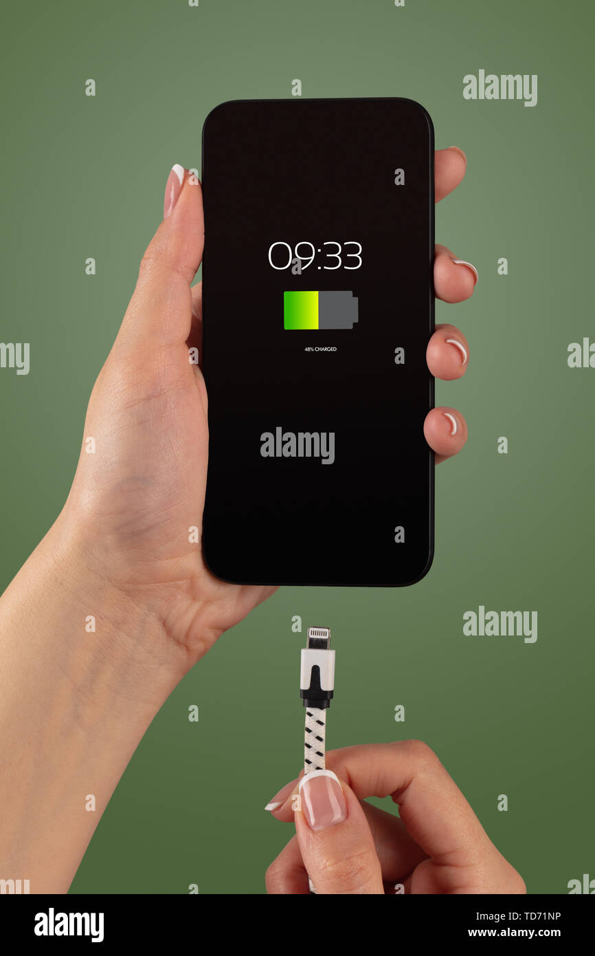 Elegant hand charging smartphone with low battery Stock Photo - Alamy