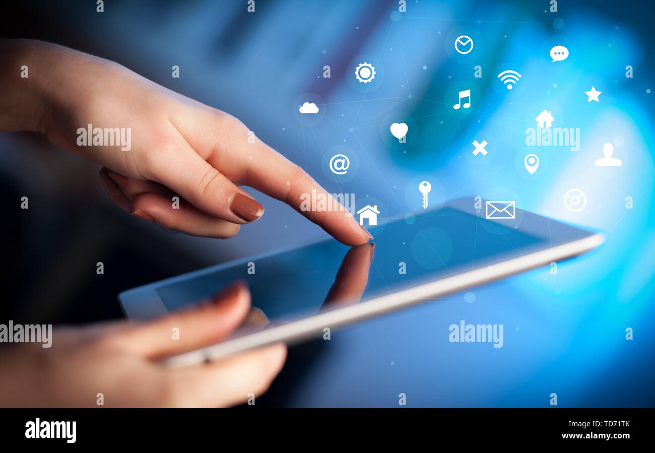 Hand holding tablet with multimedia and application symbols concept ...