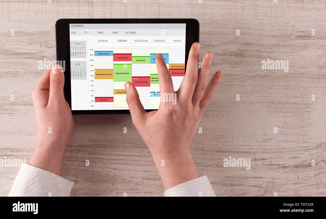 Hand holding tablet with timetable and calendar concept Stock Photo - Alamy