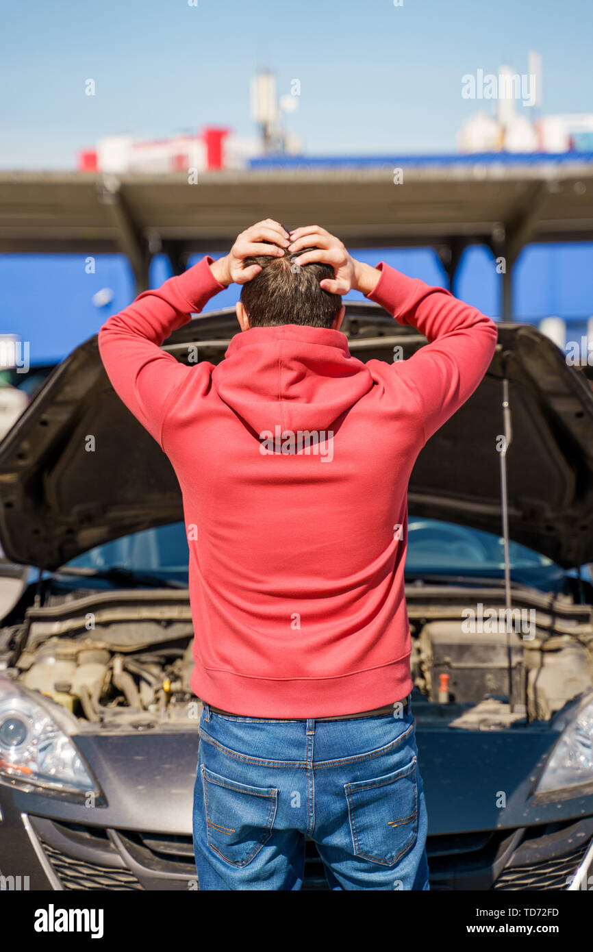 Image on back of male next to open hood of broken car in daytime Stock ...