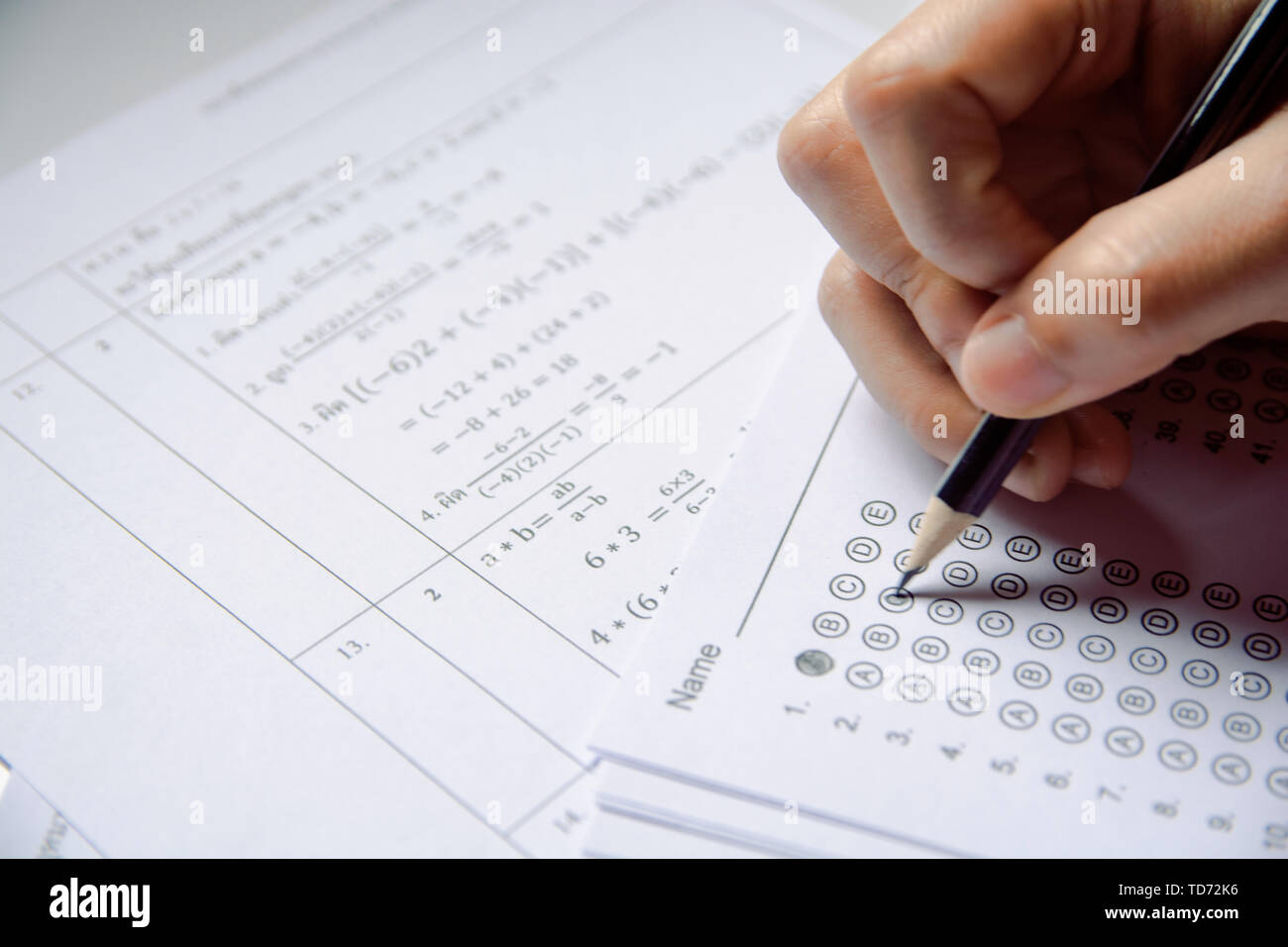 Students hand holding pencil writing selected choice on answer sheets ...