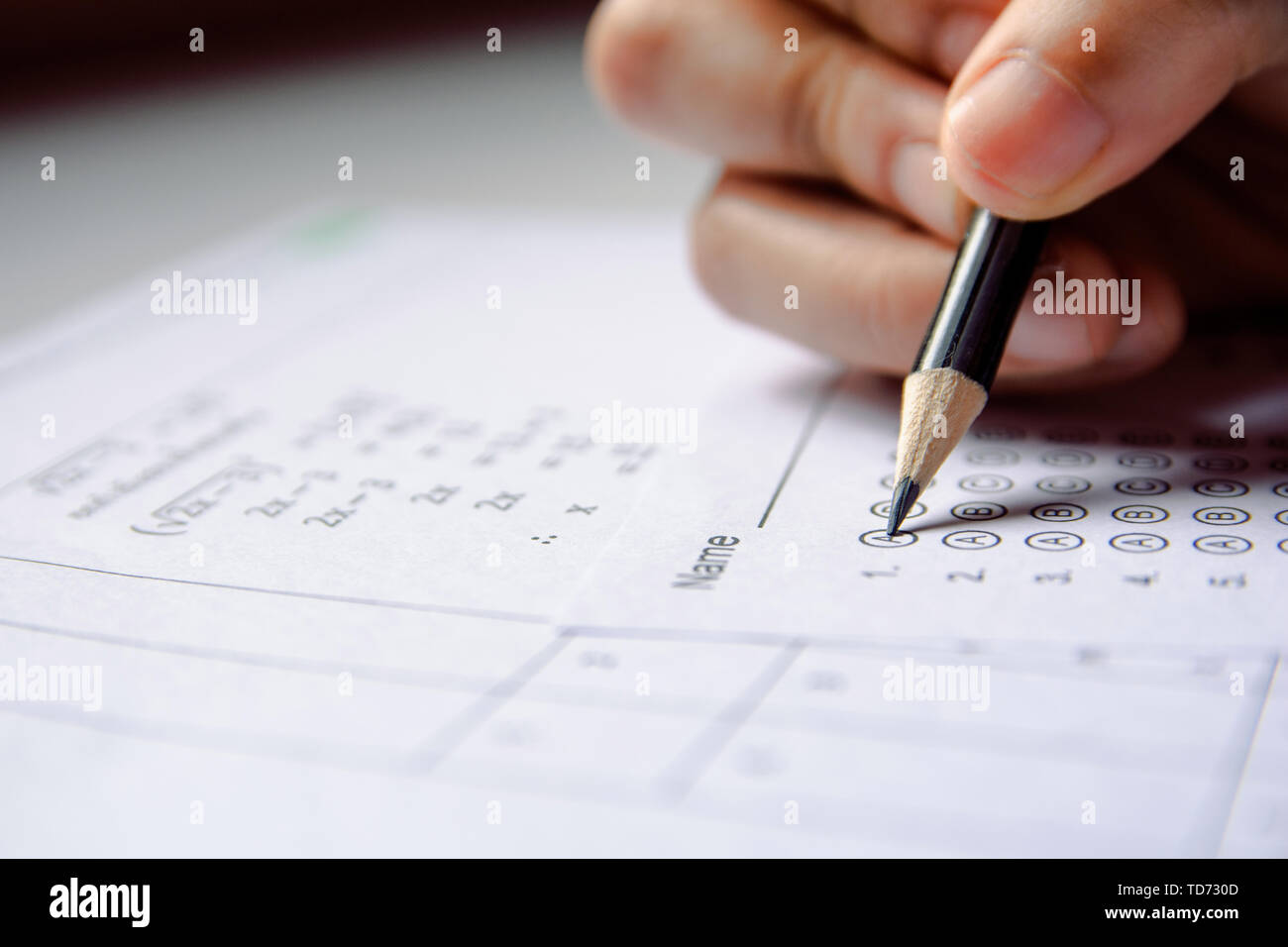 Students hand holding pencil writing selected choice on answer sheets ...