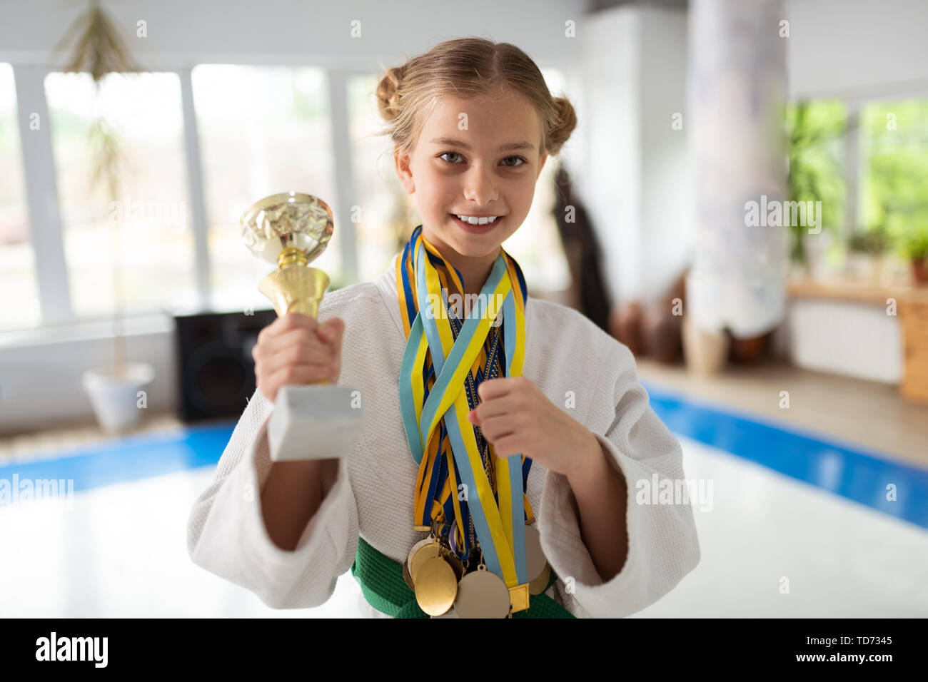Talented girl. Happy talented girl practicing aikido showing her awards ...
