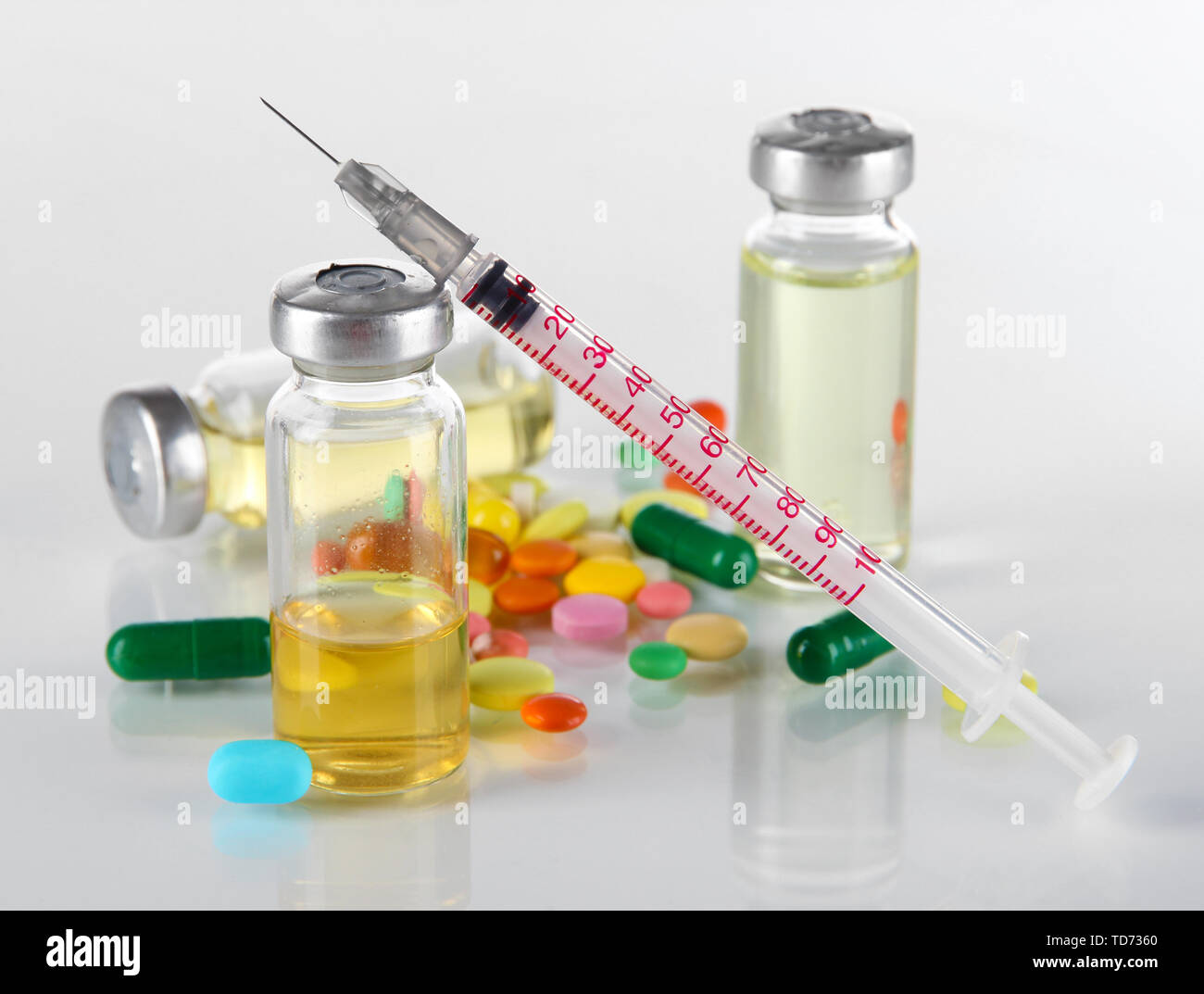 Medical bottles syringe and tablets on light gray background Stock ...